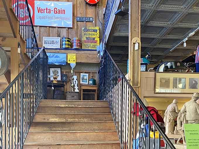 Wooden stairs flanked by iron railings lead upward, with old advertising signs cheering you along the way.