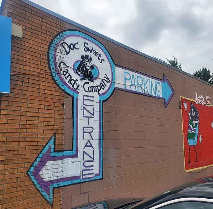 A hand-painted mural pointing toward the entrance, the most cheerful directional sign you'll ever happily follow without hesitation.