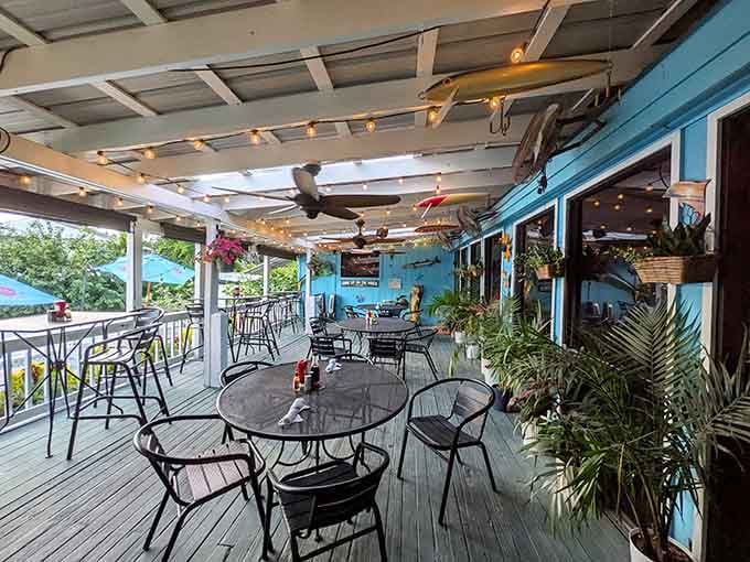 String lights, ceiling fans, and tropical plants everywhere. This outdoor patio is the kind of spot you never want to leave.
