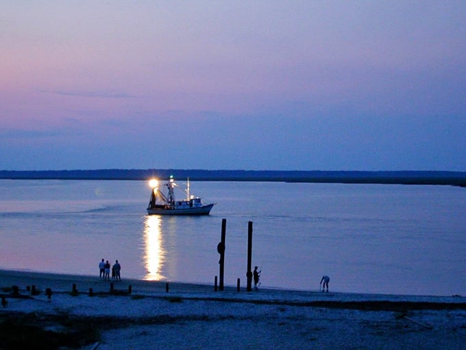 A shrimp boat glides home through the purple dusk, carrying dinner and a scene straight out of a Southern novel.