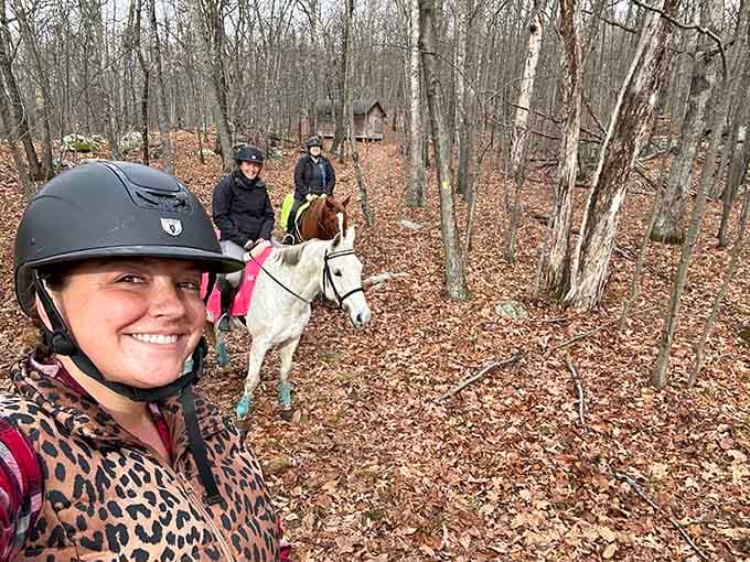 Trail riding through the bare winter woods at Farny, with a small cabin peeking through the trees like a scene from a storybook.