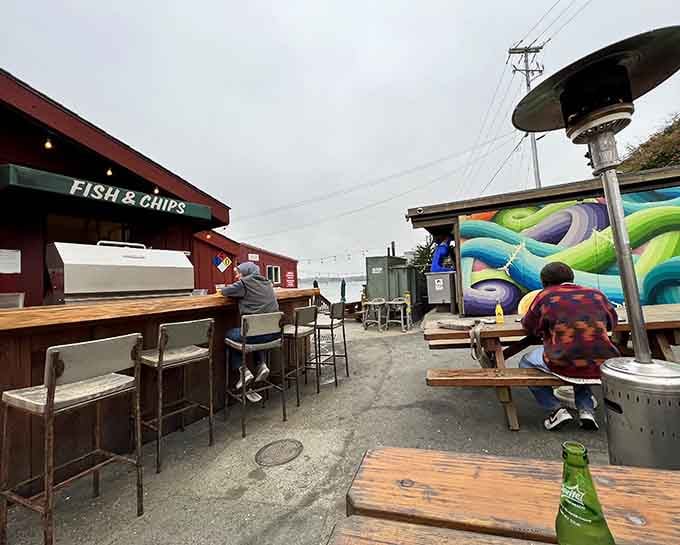 The outdoor patio faces the harbor with patio heaters, bar stools, and a colorful mural keeping things lively. Fresh air, fresh seafood, perfect afternoon.