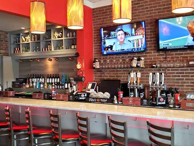 Flame-shaped pendant lights, a full bar, exposed brick, and draft taps confirm that Flamme Burger takes the whole experience seriously.