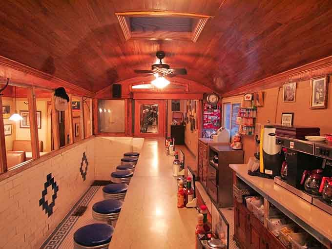 The view down the narrow aisle shows the authentic railroad car layout that makes this place truly special.