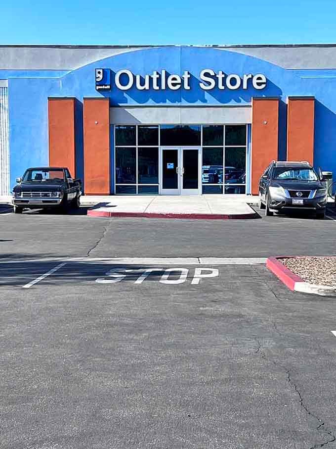 The clean, no-fuss exterior of the Goodwill Outlet Store, where the sign says stop but your bargain-hunting instincts say absolutely go in.