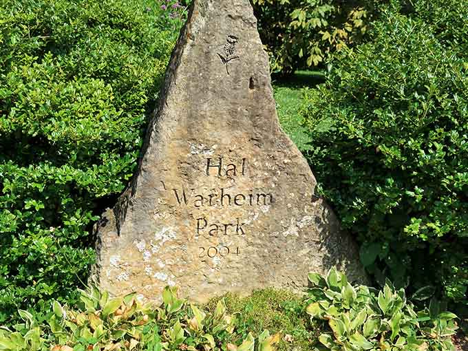 A stone marker nestled in the greenery, quietly announcing that something worth remembering happened right here.