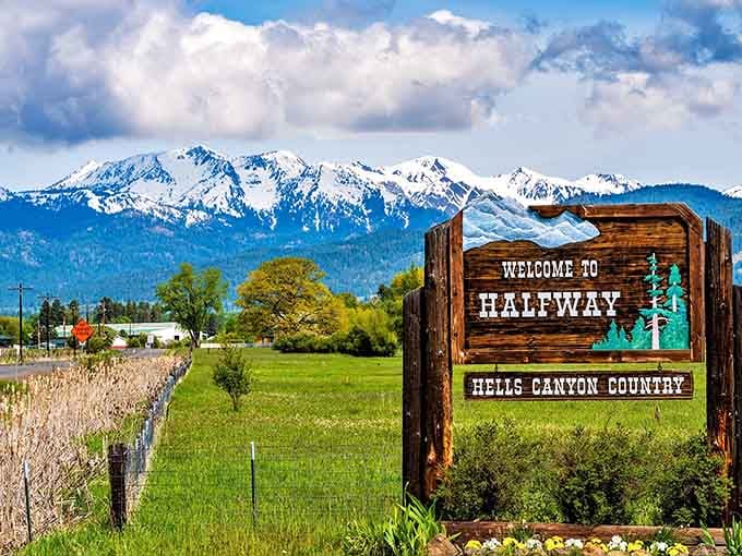 That wooden welcome sign backed by snow-covered mountains and spring wildflowers is basically Halfway saying, "Yes, we really are this good."