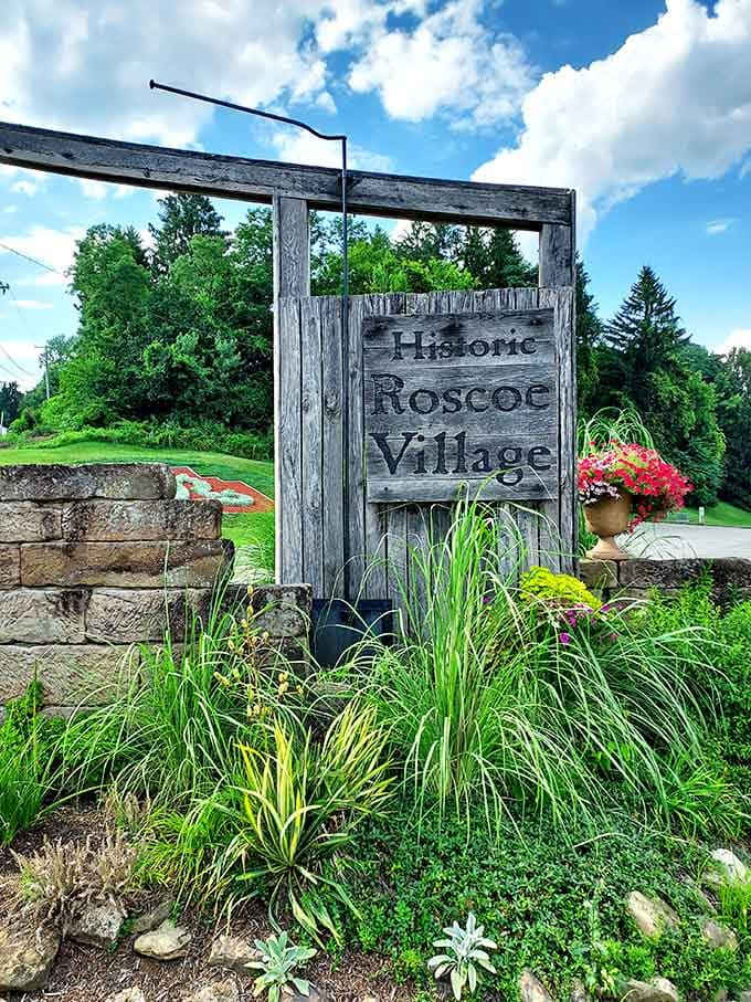 That weathered wooden sign rising from stone and wildgrass is basically history itself saying, "You found us. Finally."