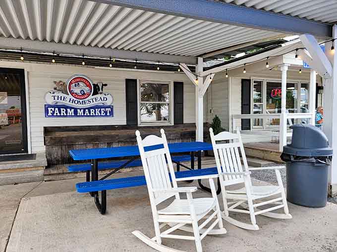 Two white rocking chairs, a blue picnic table, and string lights overhead, this porch is basically an invitation to slow down and stay awhile.