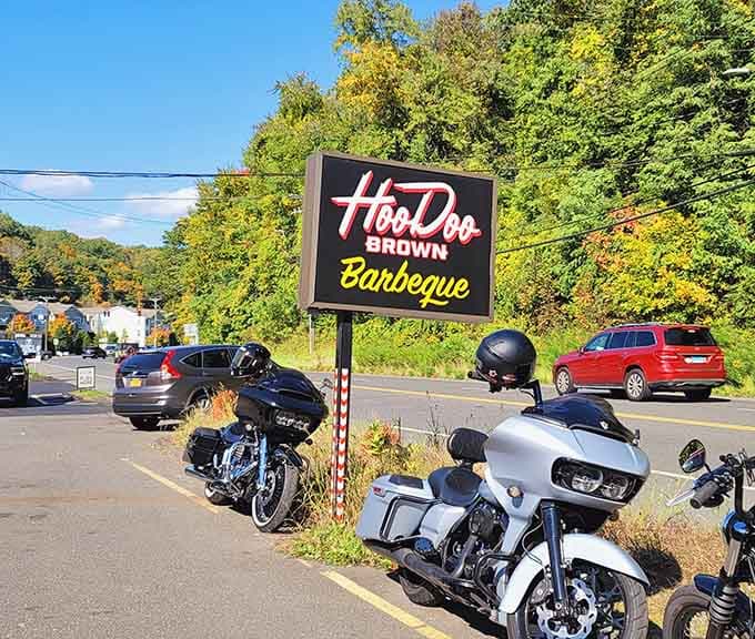 Motorcycles parked beneath the sign on a crisp fall day. Hoodoo Brown draws all kinds, and they all leave happy.