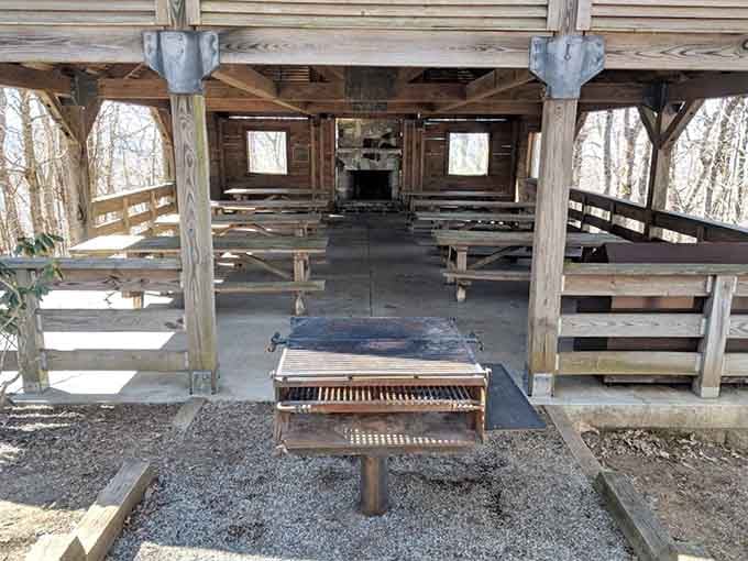 A covered shelter with long wooden benches and a stone fireplace, because this mountain believes in hospitality.