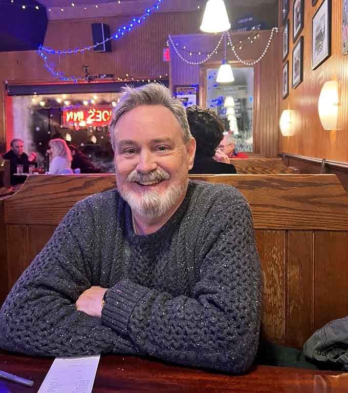 A happy diner settled into a cozy booth at Joe's Inn, looking like someone who made an excellent decision tonight.