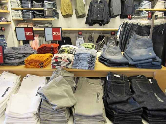 Denim stacks organized by color like a rainbow made entirely of jeans and good financial decisions.
