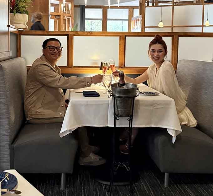 Two happy diners toasting with champagne at Leo's, proof that great seafood makes every occasion worth celebrating.