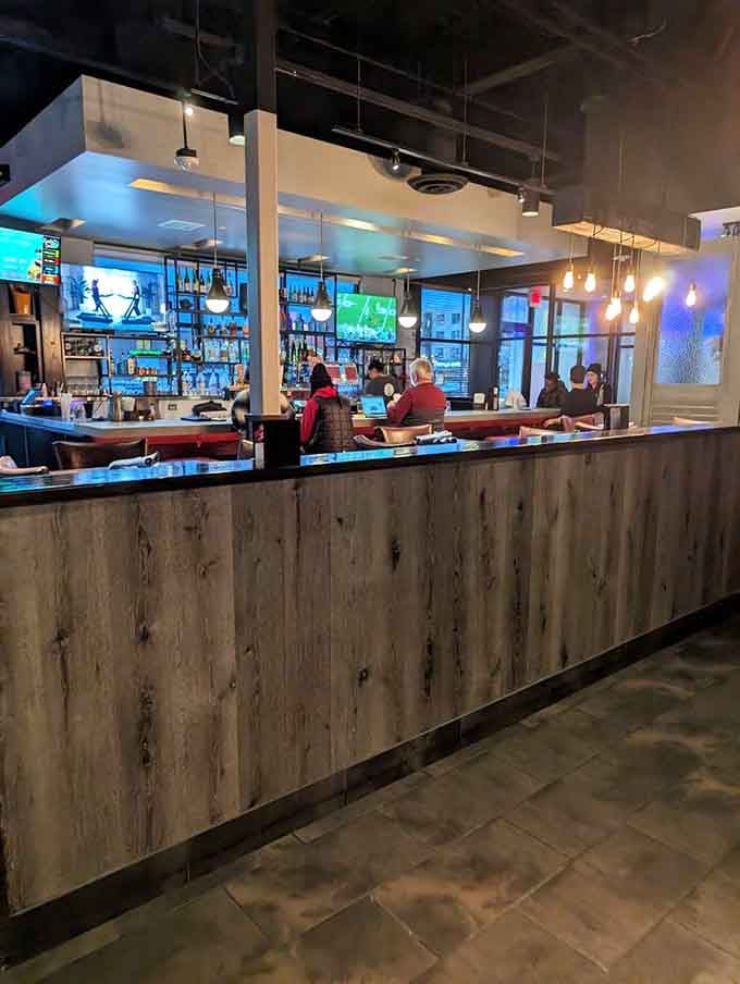 A well-stocked bar with warm Edison bulbs glowing, the kind of spot where good conversations start naturally.
