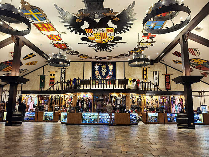 The Hall of Arms greets you with coats of arms overhead and souvenirs below, a proper royal welcome.
