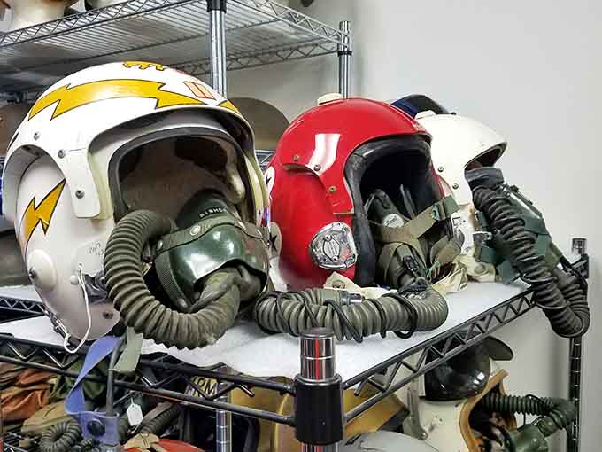 A shelf full of fighter pilot helmets and oxygen masks, each one with a story its owner never forgot.