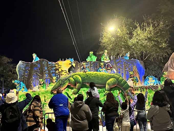 A Mardi Gras float lit up at night, rolling past crowds, is Mobile saying, "New Orleans who?"