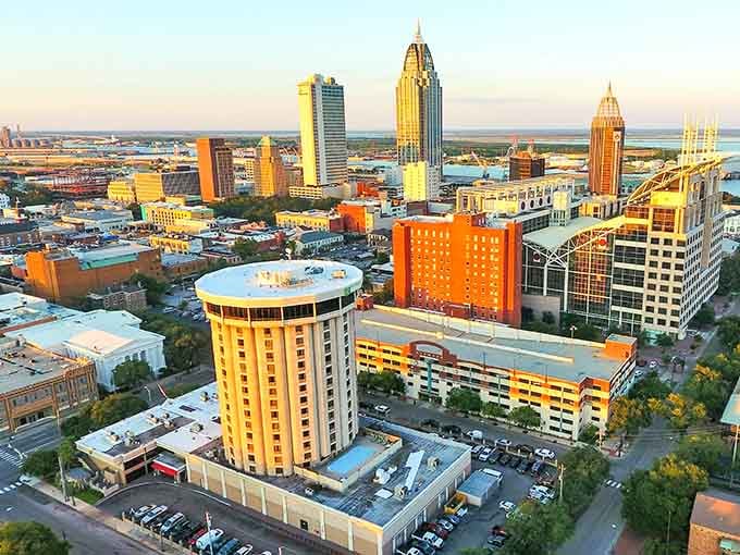 Mobile's aerial view reveals a coastal city bathed in golden light, where the bay meets downtown in perfect harmony.