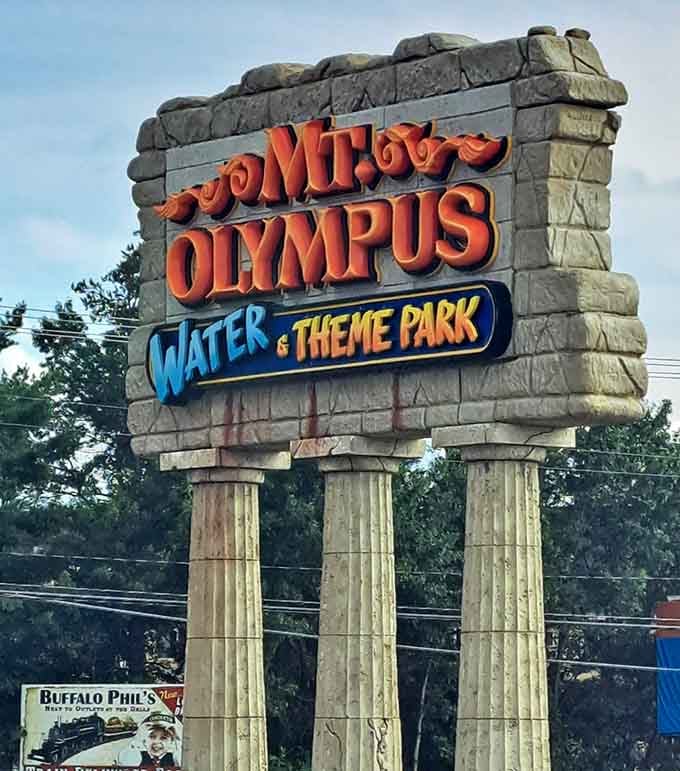 Three stone columns holding up the Mt. Olympus sign, quietly announcing that something extraordinary is waiting just beyond those trees.