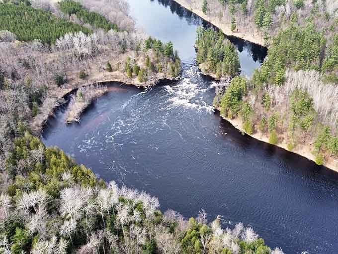 From above, the Menominee River bends through the forest with the quiet authority of something that has always been in charge.