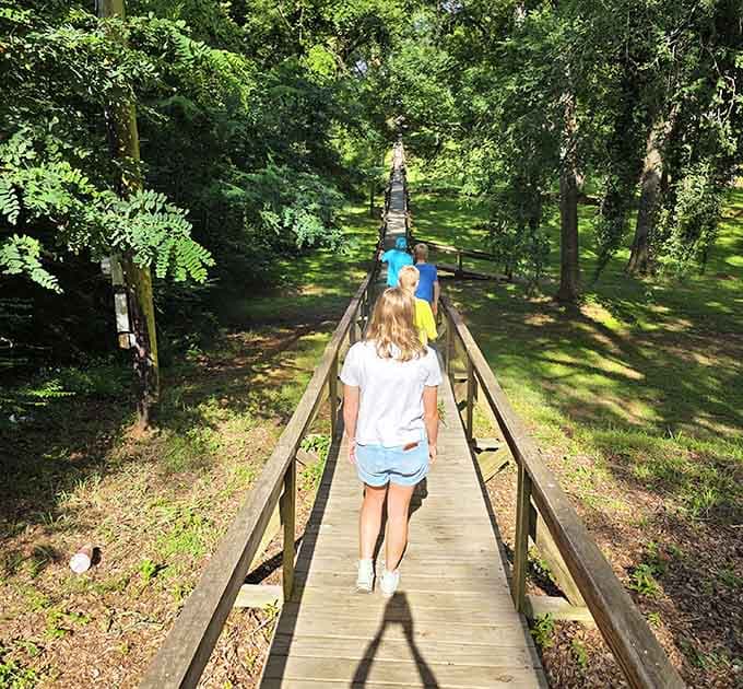 Kids on a wooden bridge through the trees, completely unplugged and completely happy. Some things never go out of style.