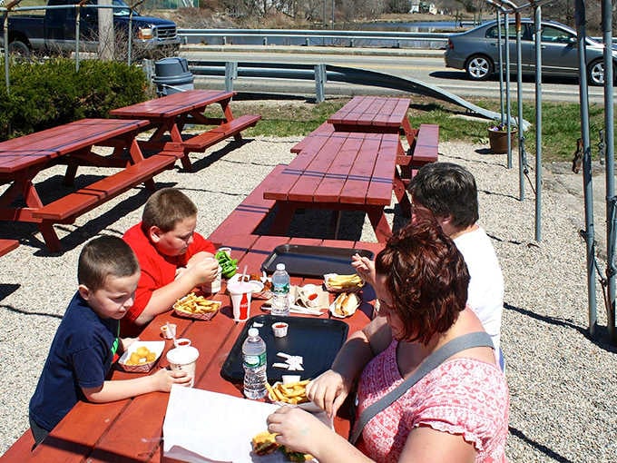 Families gathered around picnic tables, trays full of food, proof that the best meals need no roof.