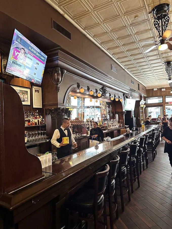A bartender in a bow tie behind a polished bar counter, some things in life should never change.