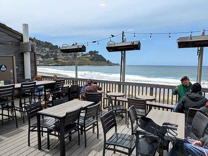 People actually sitting on a Taco Bell deck watching the Pacific Ocean roll in. This is a real place you can visit.