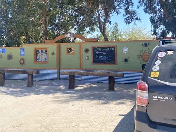 A cheerful hand-painted entrance sign welcoming visitors, because even a dome built from alien blueprints knows good hospitality matters.