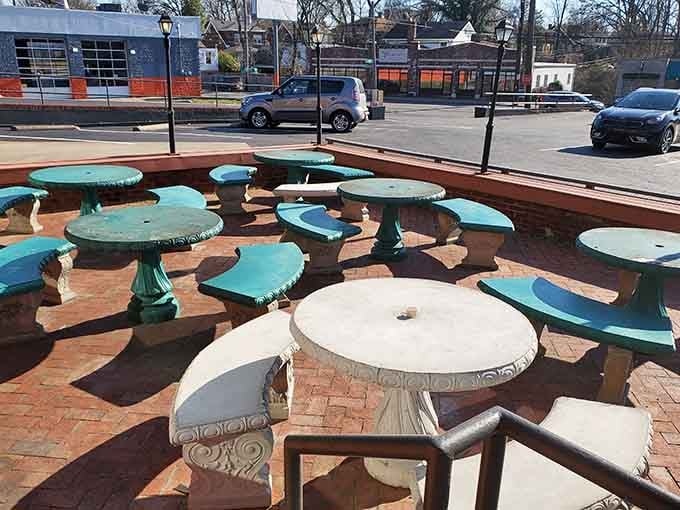 Outdoor concrete tables on a sunny Bardstown Road afternoon, the perfect spot for pie and people-watching.