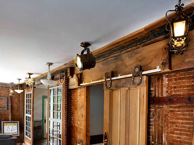 Sliding barn doors, mismatched vintage lights, and exposed brick. This hallway has more soul than most hotels.