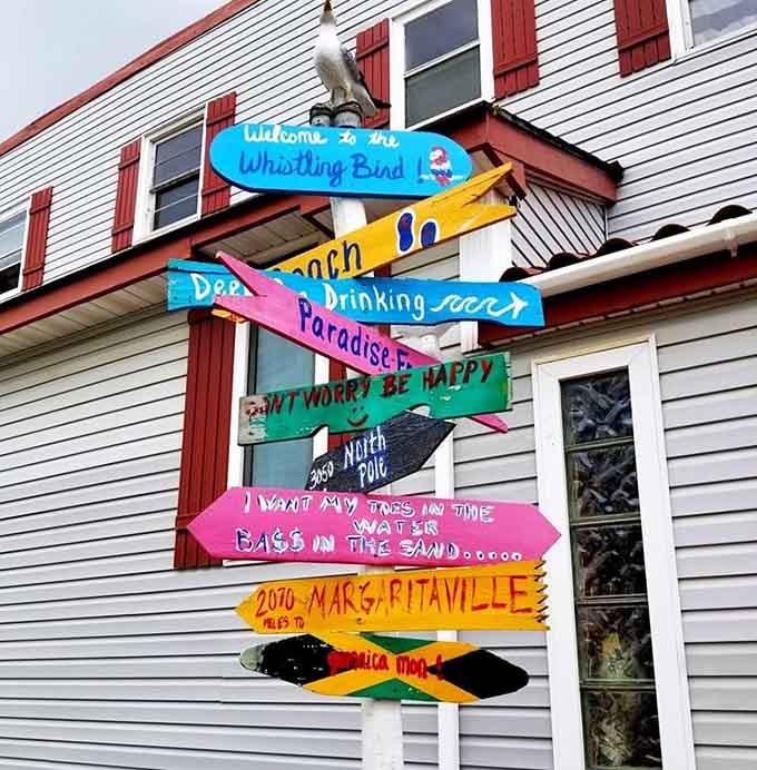 A colorful signpost pointing toward Margaritaville, the beach, and paradise, all conveniently located in Gilbert, Minnesota.
