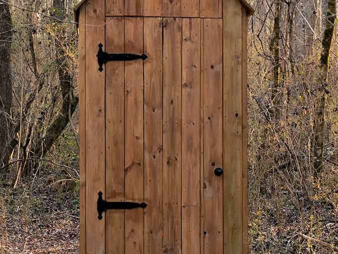 A sturdy wooden bathhouse standing quietly among the trees. Rustic, charming, and exactly what this adventure needs to feel complete.