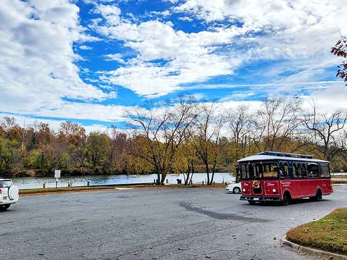 Autumn colors blazing along the Rappahannock River shoreline, dramatic clouds overhead, and a trusty red trolley parked nearby — Virginia, you really outdid yourself.