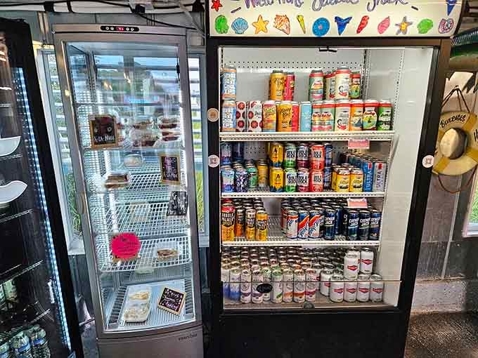 A cold beer fridge stocked and ready, right next to the dessert case. Priorities, perfectly arranged.