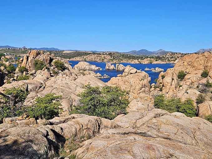 Warm granite boulders stretch in every direction, with the deep blue lake peeking through every gap between them.