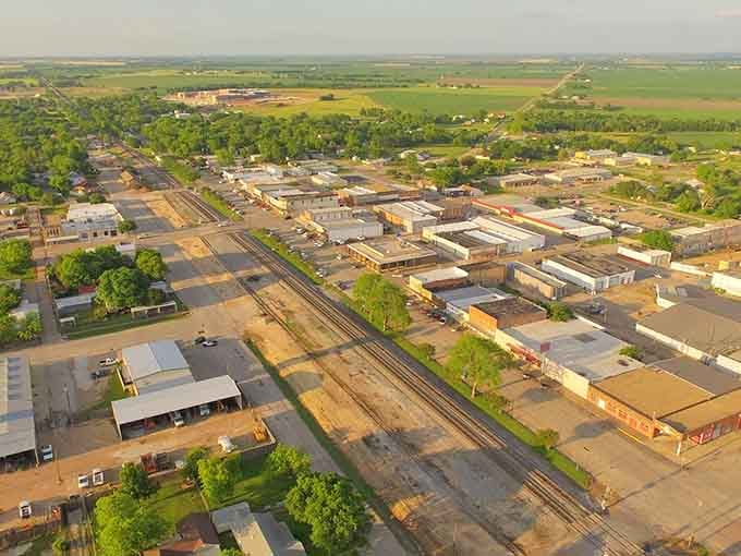 From above, West spreads across the prairie like a perfectly planned postcard, railroad tracks stitching past into present.