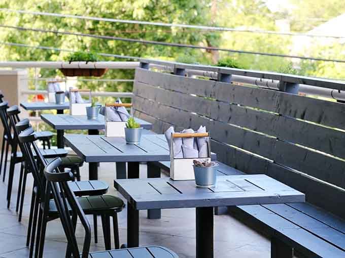 Rooftop dining with tree canopy views and dark wood tables makes this outdoor deck a genuine Atlanta treasure.