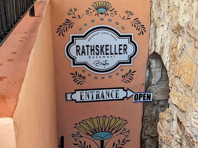 That charming entrance sign is your first clue that something special awaits below street level.