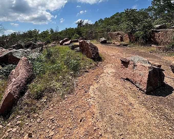 Ancient red granite boulders scatter across this sun-baked trail like nature's own furniture arrangement, billions of years in the making.