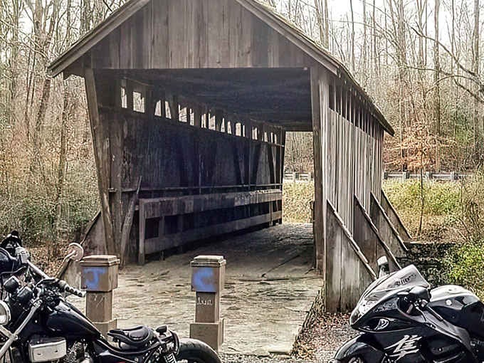 Two motorcycles parked here prove this weathered wooden bridge still knows how to draw a crowd.