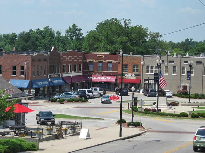 Classic storefronts and red umbrellas create a Main Street scene that looks like it stepped out of a Norman Rockwell painting.