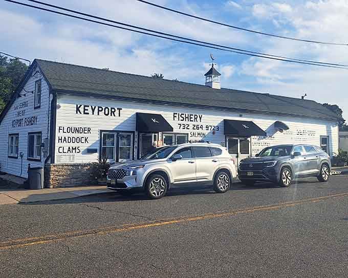 That white clapboard building painted with "Flounder, Haddock, Clams" is basically a menu and a masterpiece rolled into one.
