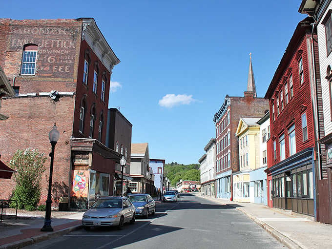 Historic brick buildings line these charming streets where church steeples pierce blue skies like postcards from another era.