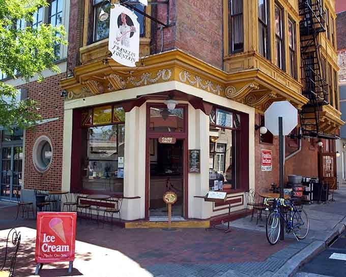 That ornate gold trim and swinging sign say one thing clearly: something wonderful happens inside this corner building.