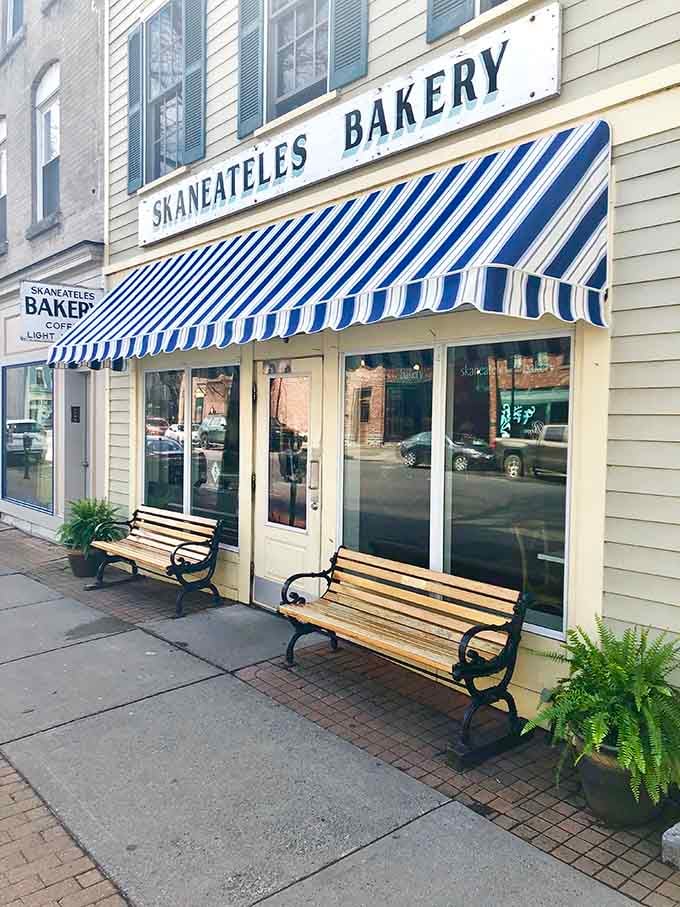 That blue and white striped awning isn't just charming, it's practically a hug from the building itself.