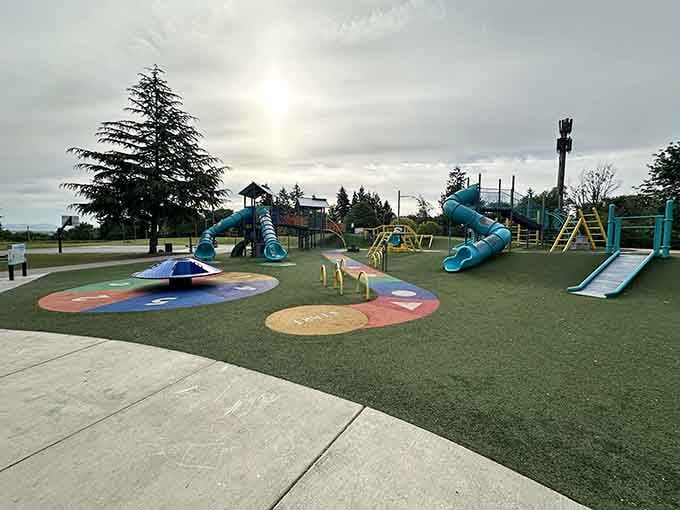 A cloudy sky can't dim the joy here, where teal slides and rainbow turf turn an ordinary afternoon into pure magic.