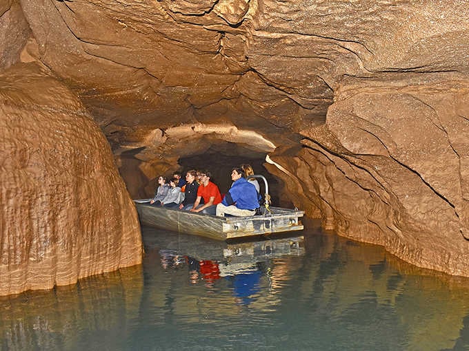 The rippling water mirrors the rust-colored cave ceiling, making every passenger feel delightfully swallowed by the earth.