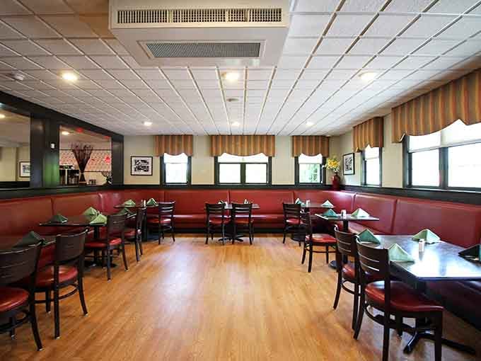 Red leather booths, warm wood floors, and folded napkins waiting patiently — this dining room means business tonight.